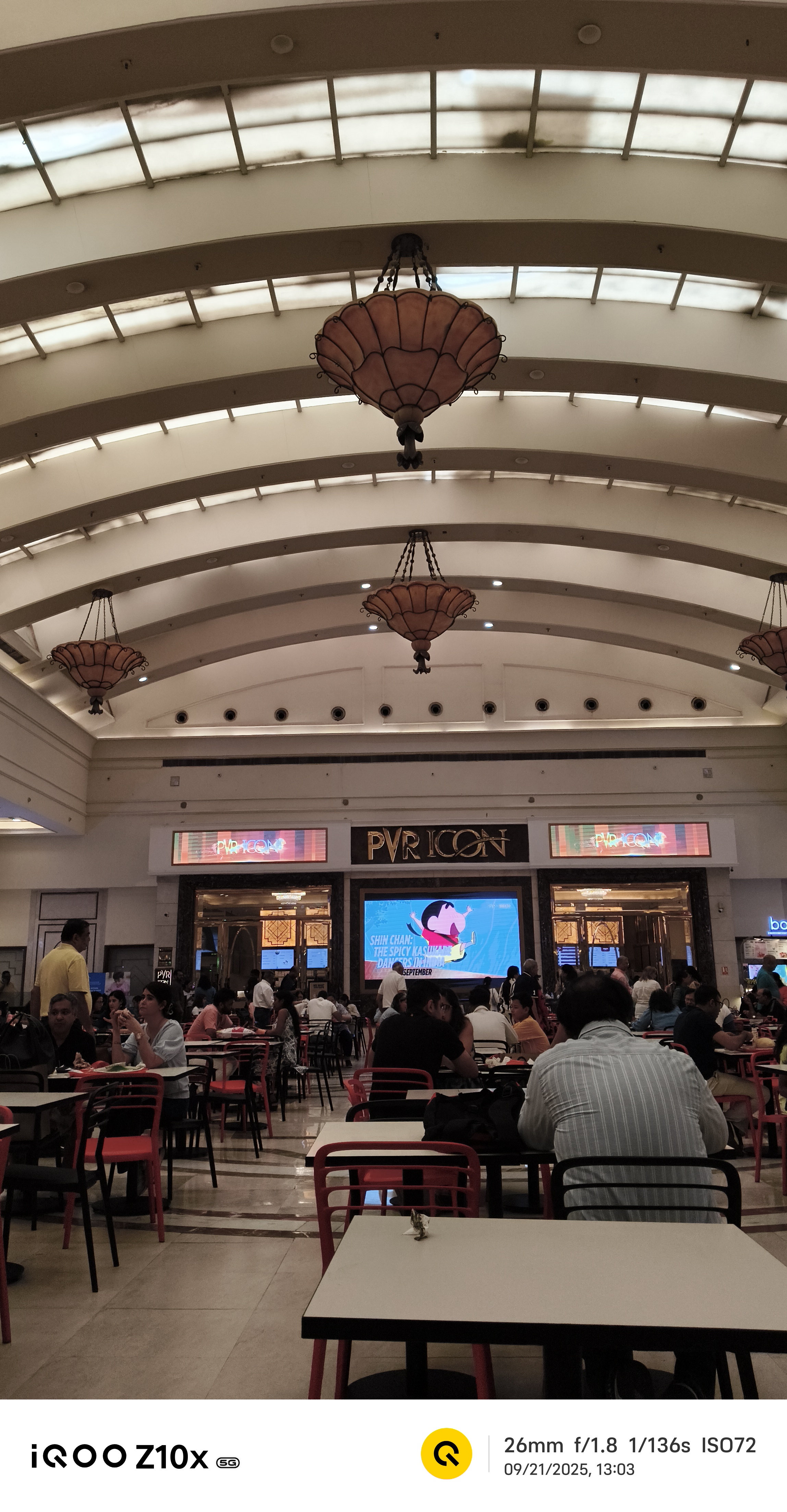 . A large shopping mall crowded with people enjoying meals and shopping ...